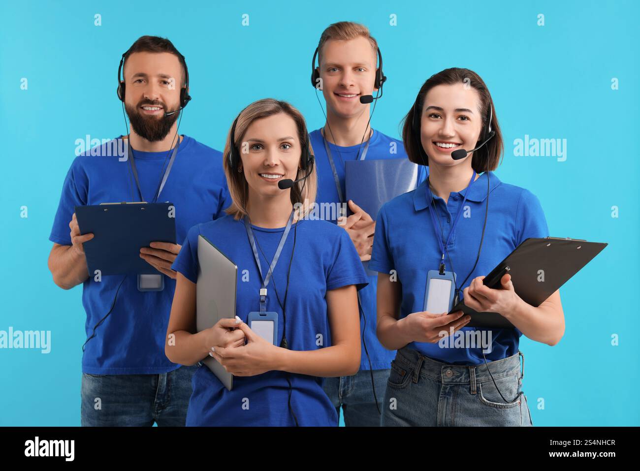Technical support call center. Team of friendly operators on light blue ...