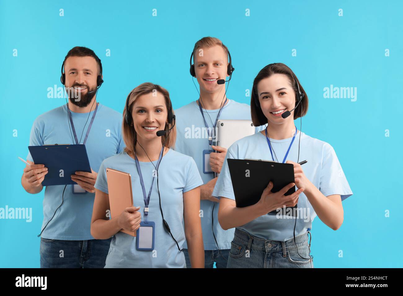 Technical support call center. Team of friendly operators on light blue ...