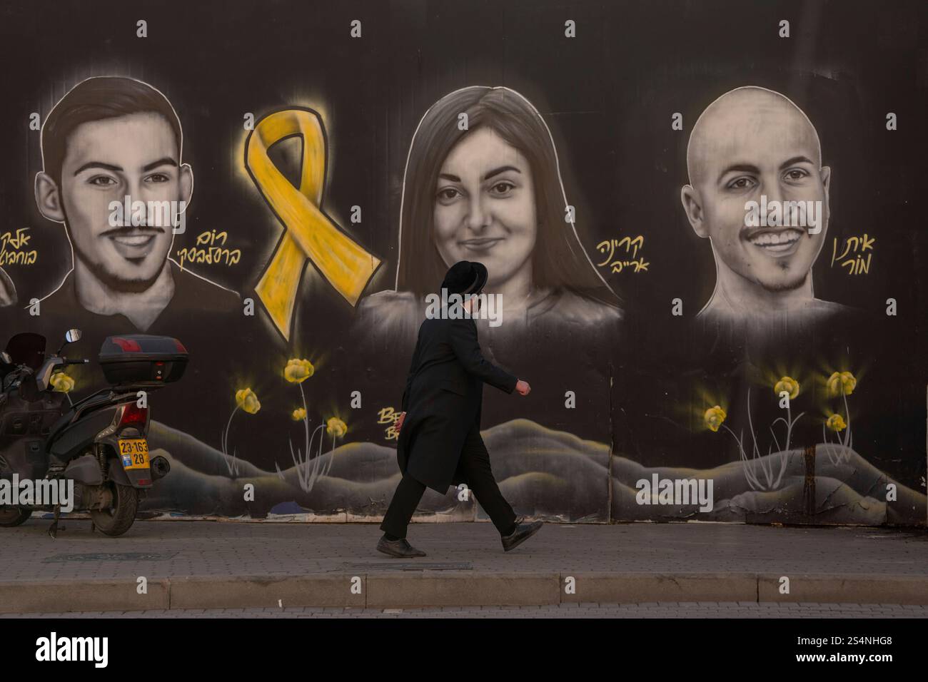 An Ultra-orthodox Jewish man walks past a graffiti that displays ...