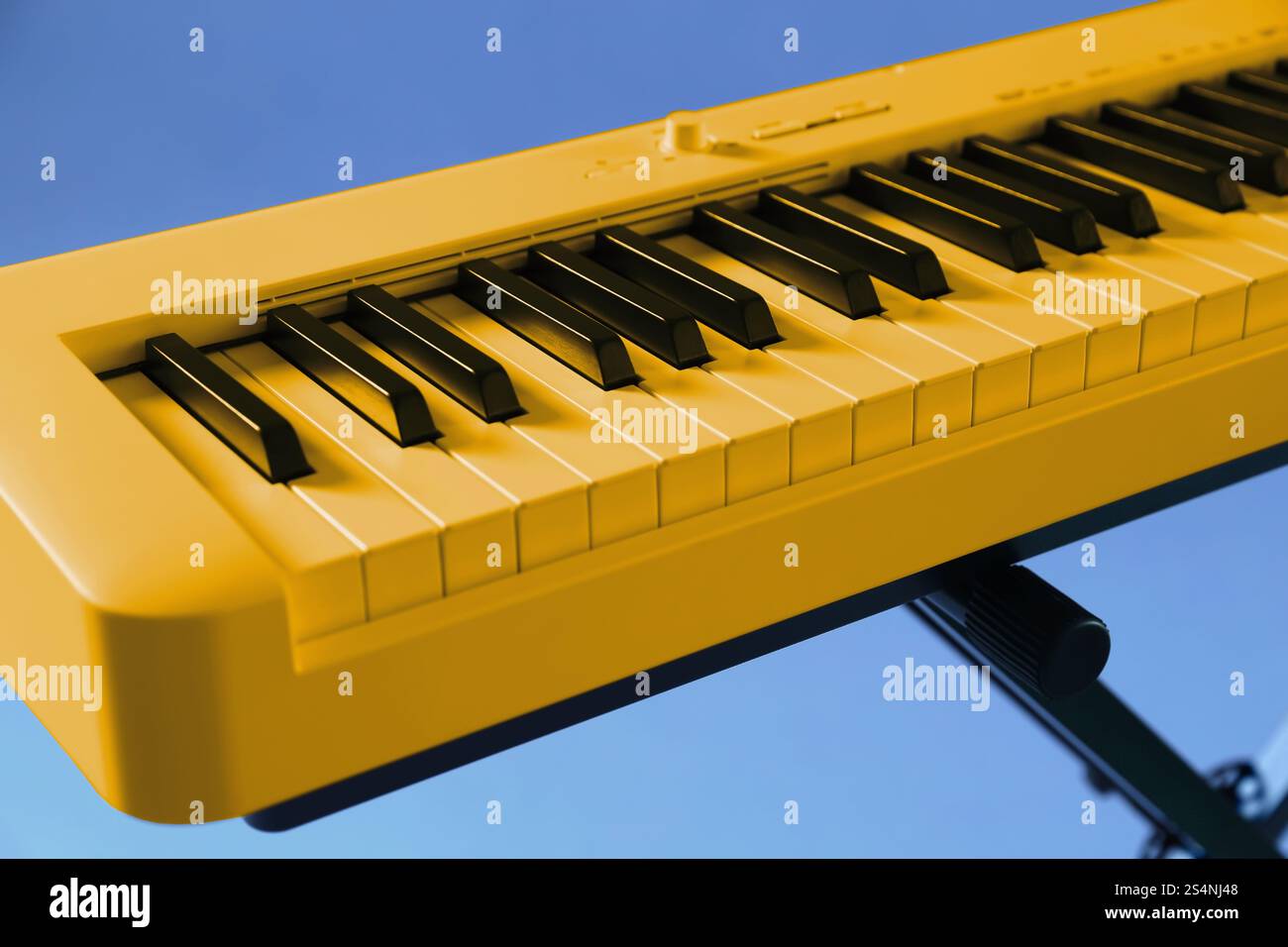 Yellow synthesizer on light blue background, closeup. Electronic ...