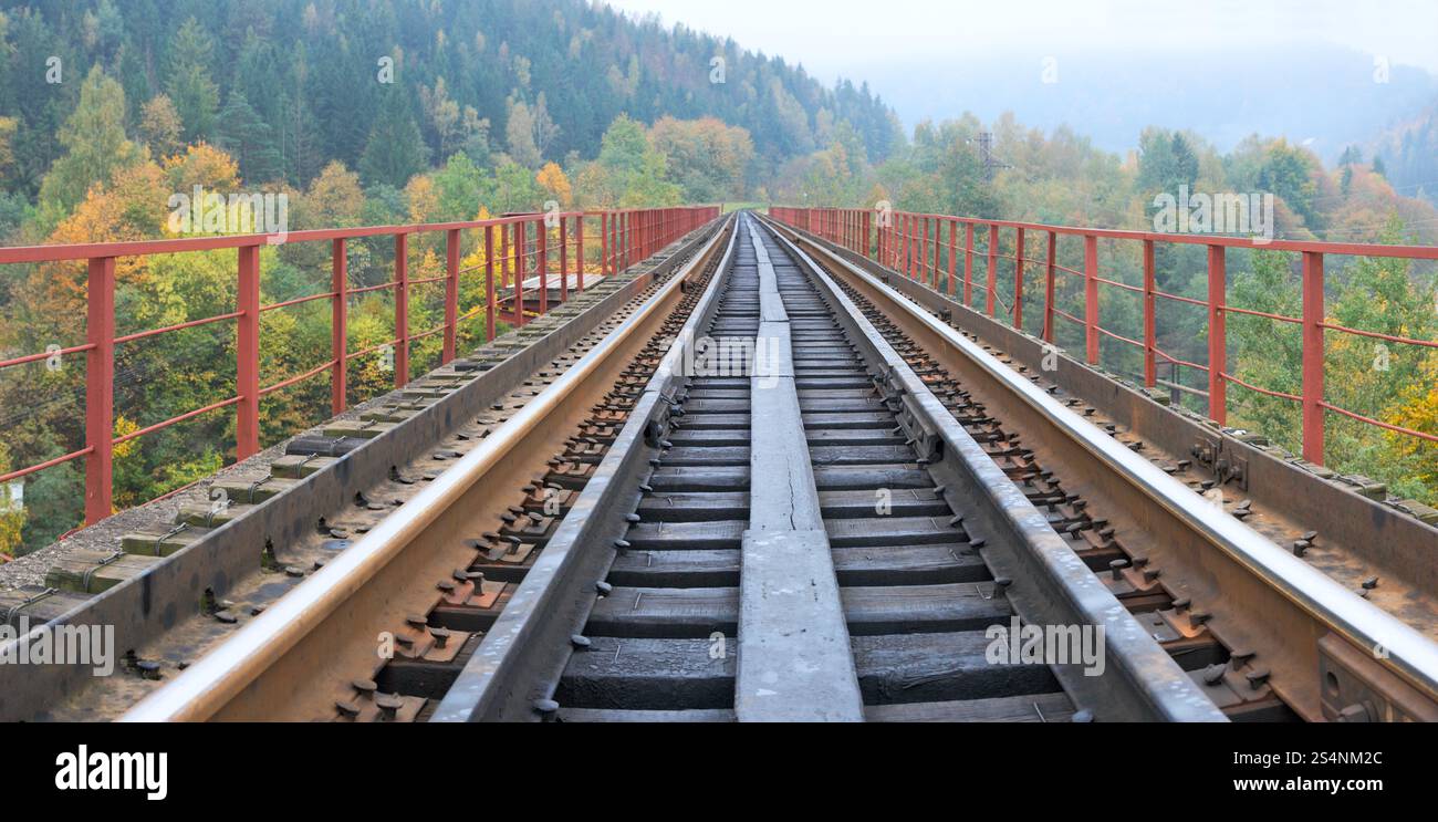 Railway on bridge across mountain river. Autumn, four shots composite ...
