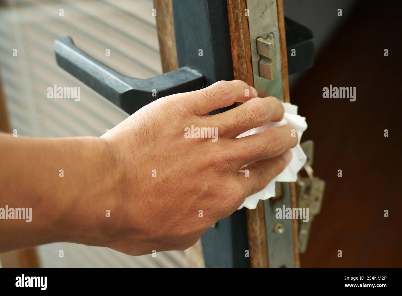 hand cleaning the door lock iron Stock Photo - Alamy
