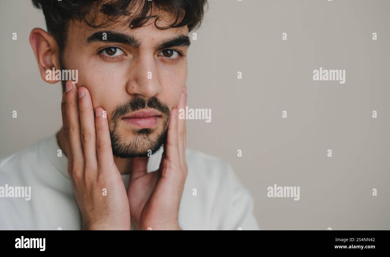 A contemplative young man with an exceptionally stylish haircut and a ...