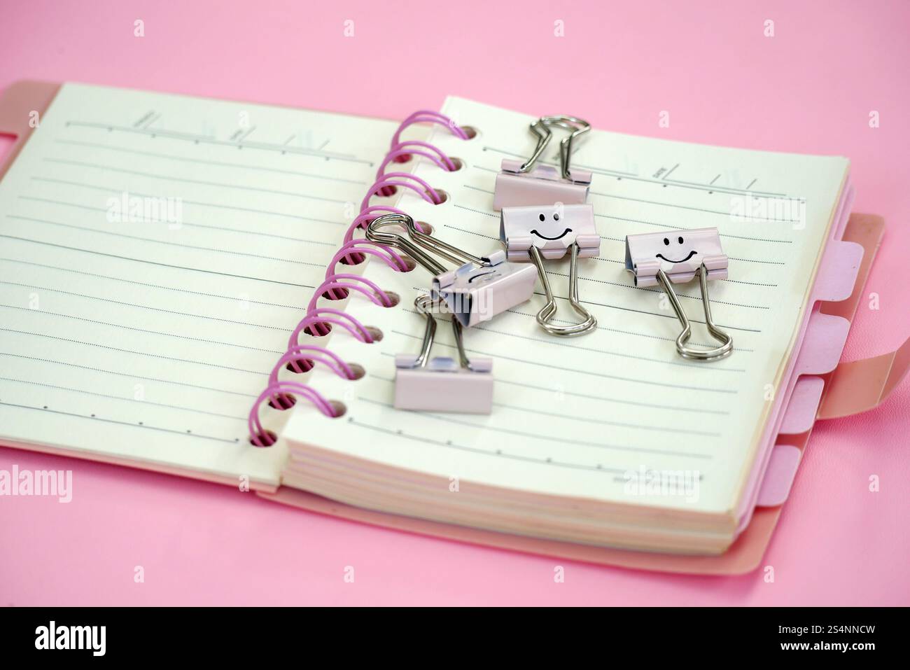 Smile emoji clip paper on spiral notebook with pink background Stock ...