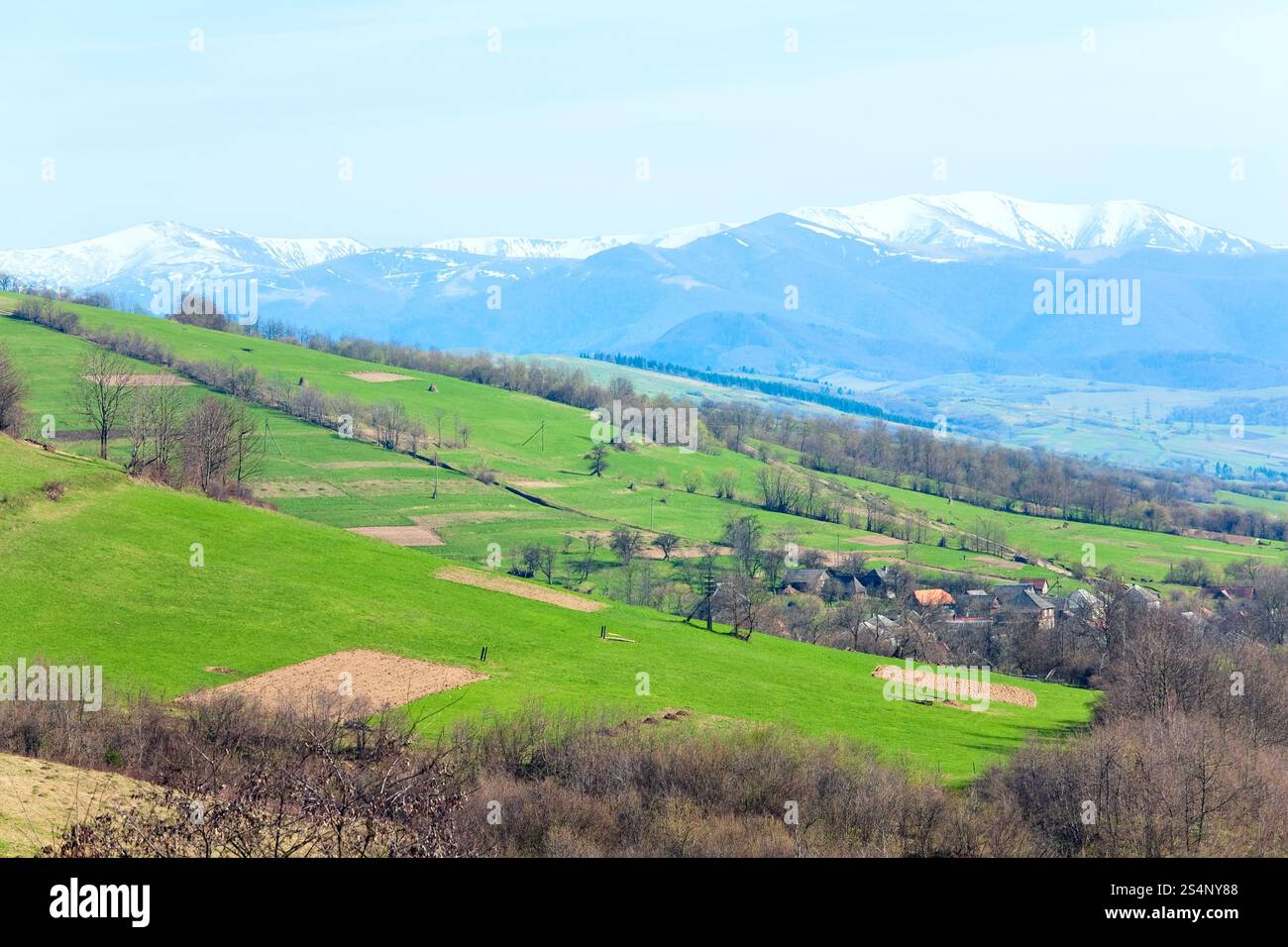 Spring mountain country valley view with farm fields and mountains in ...