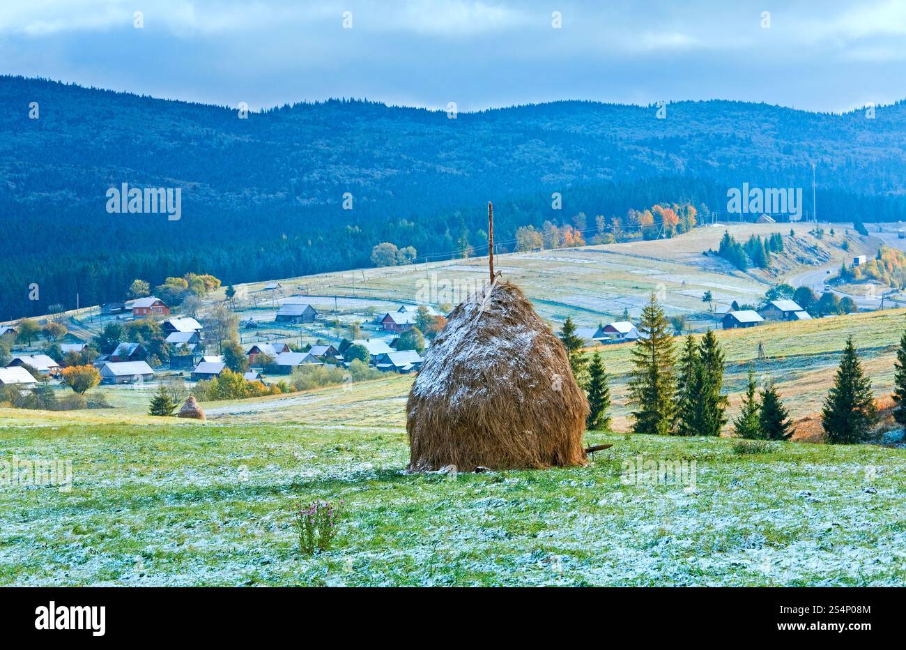 First winter snow on October Carpathian mountain plateau with village ...