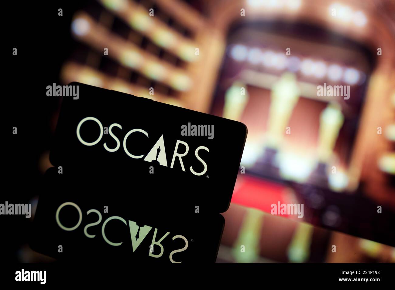 A smartphone displaying the Oscars logo against a blurred awards ...