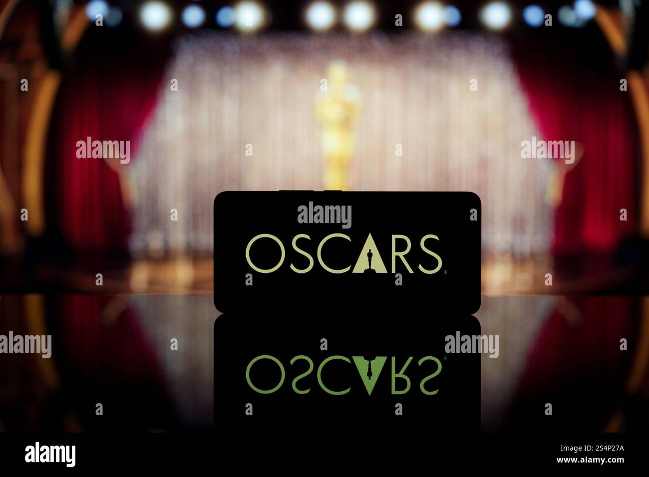 A smartphone displaying the Oscars logo against a blurred awards ...