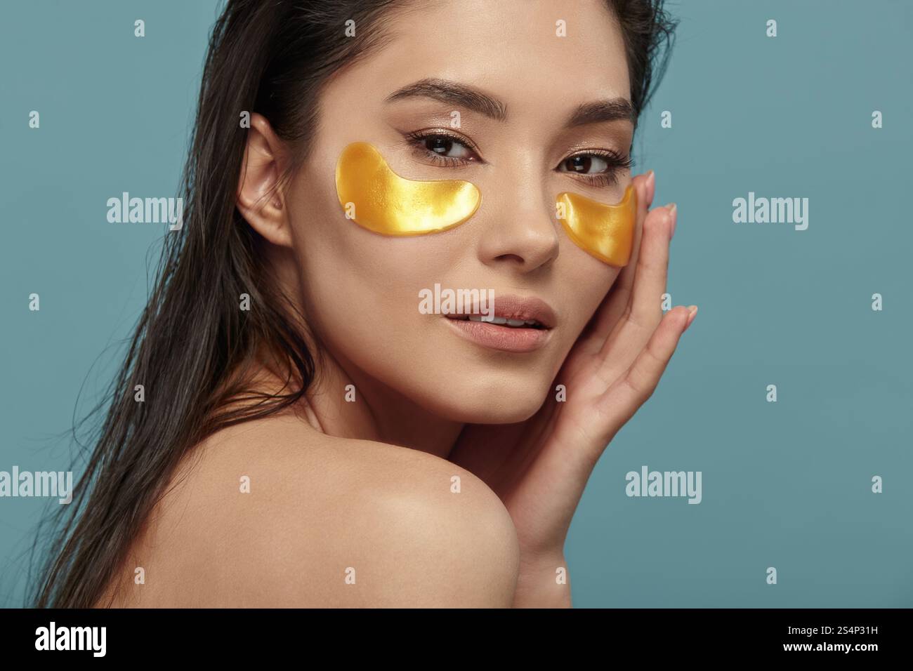Asian Woman Applying Under Eyes Mask With Patches Against Blue Isolated ...