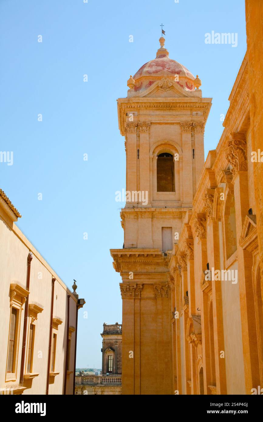 straight baroque style street with houses from yellow sandstone in Noto ...