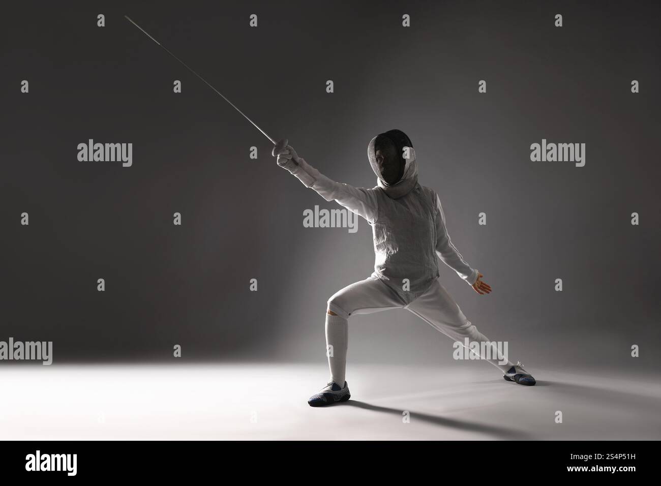 Fencer with epee practicing on gray background Stock Photo - Alamy