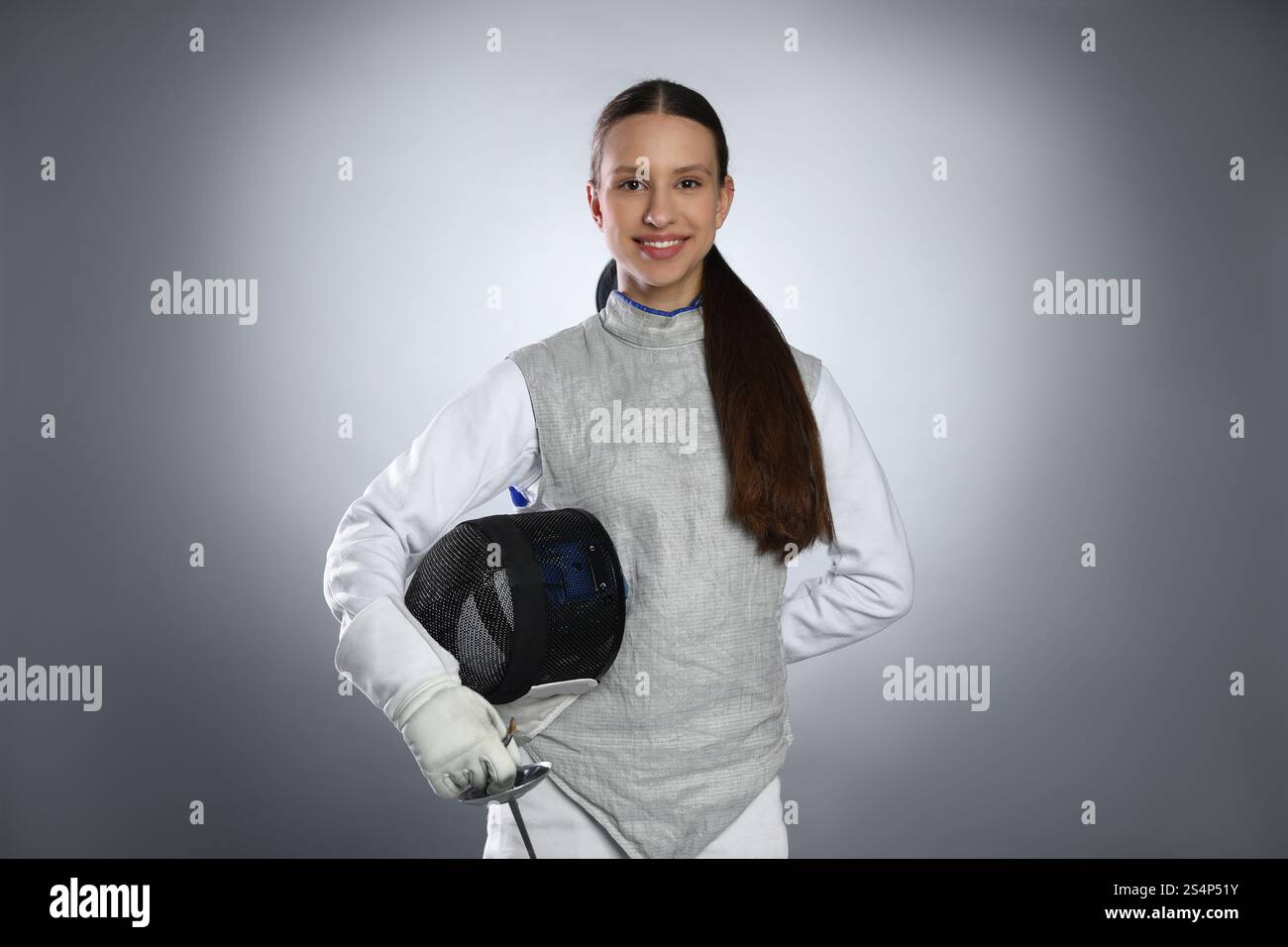 Smiling fencer with epee on gray background Stock Photo - Alamy