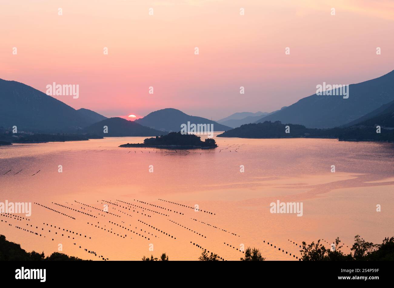Pink sea sunset and islands on horizon. View from PeljeA?ac peninsula ...