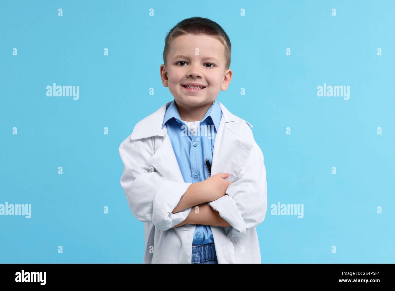 Little boy pretending to be doctor on light blue background. Dreaming ...