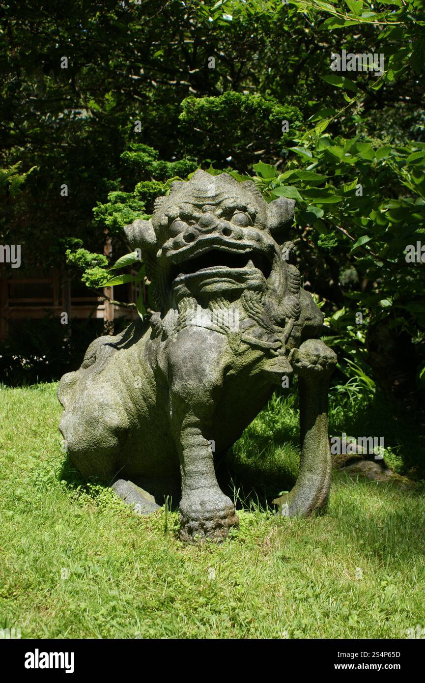 Stone statue of a lion in japanese garden. Japanese stone statue of a ...