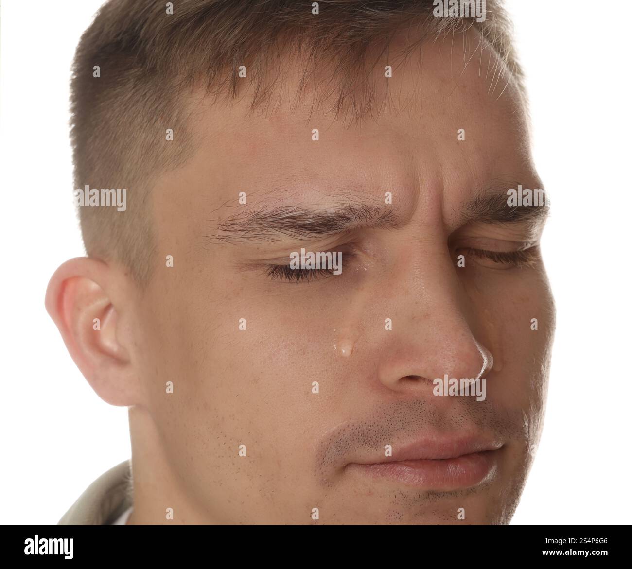 Distressed young man crying on white background Stock Photo - Alamy