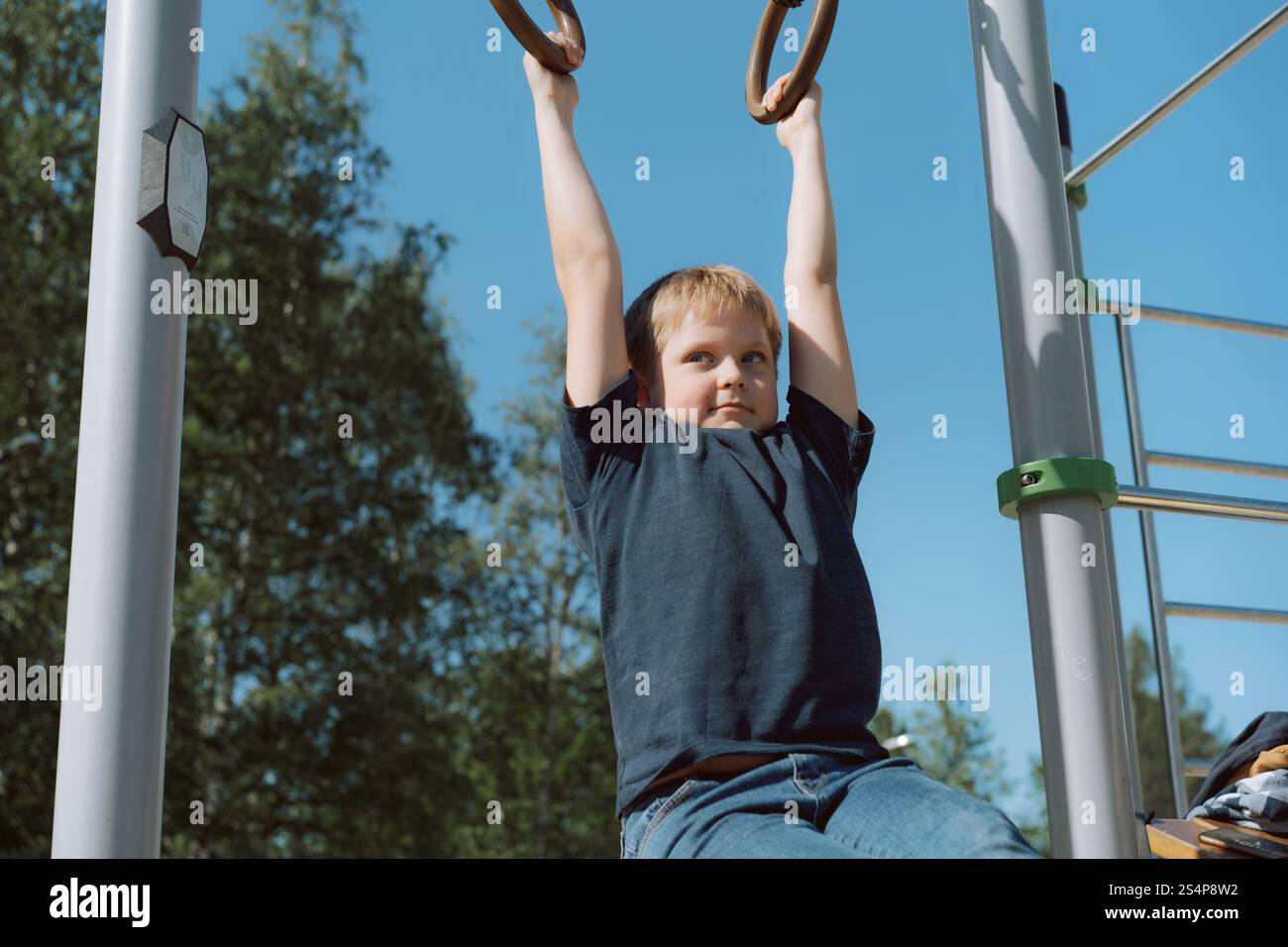 boy pull-up on rings at outdoor sportsground Stock Photo - Alamy