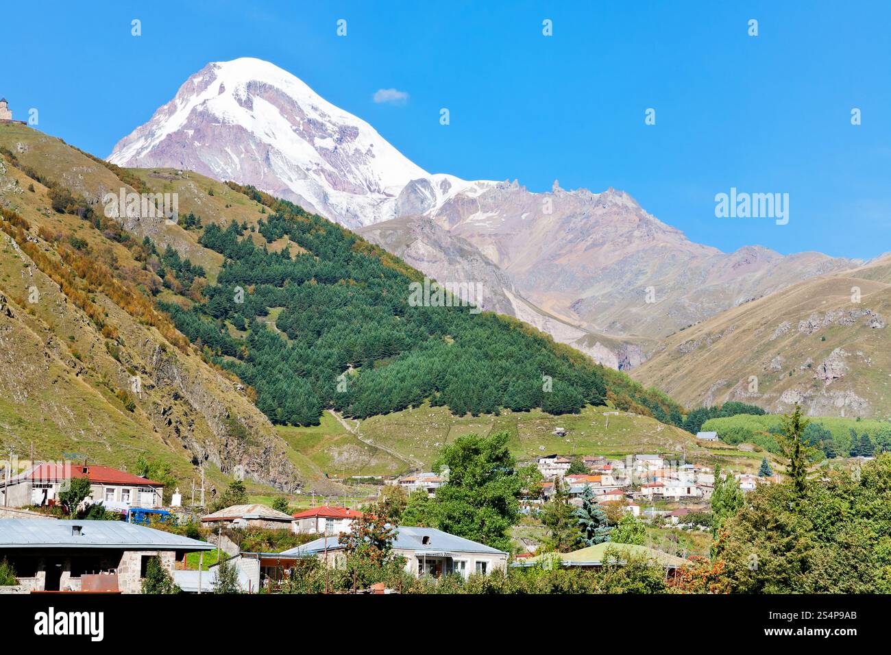 view of village Stepantsminda, Gergeti Trinity Church and Mount Kazbek ...