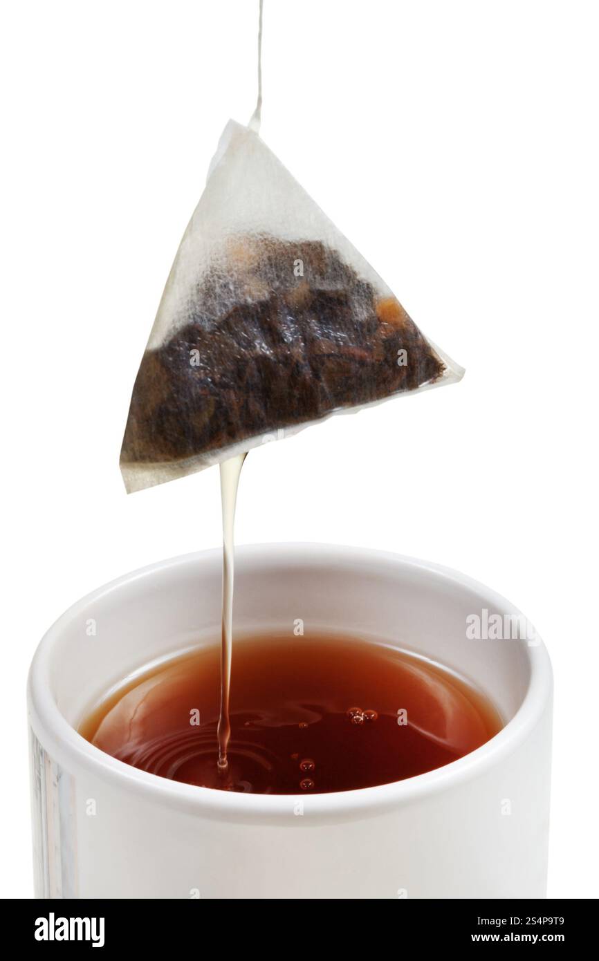 removing of tea bag from cup with brewing tea close up isolated on ...