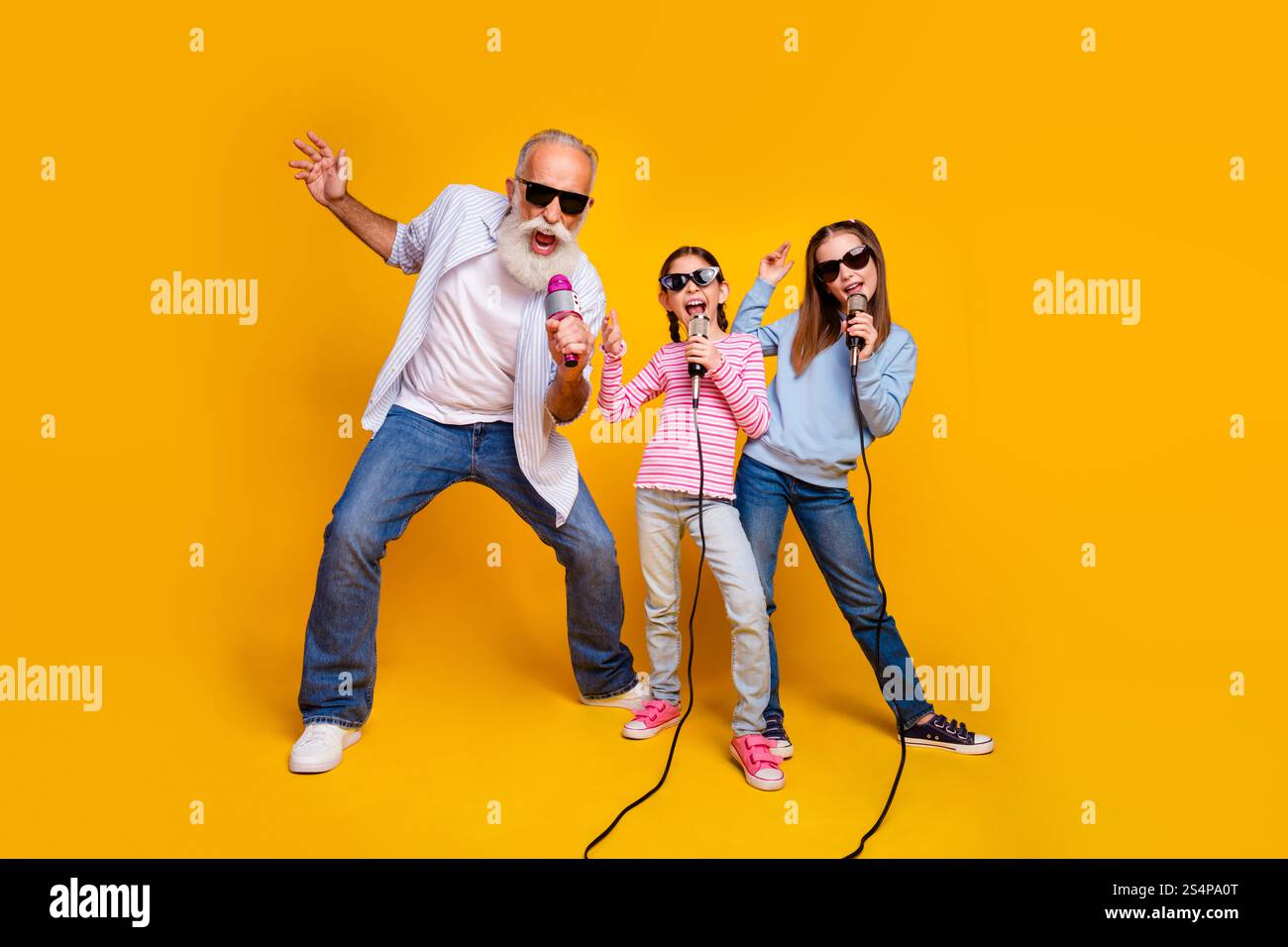 Happy family group singing karaoke on joyful yellow background Stock ...