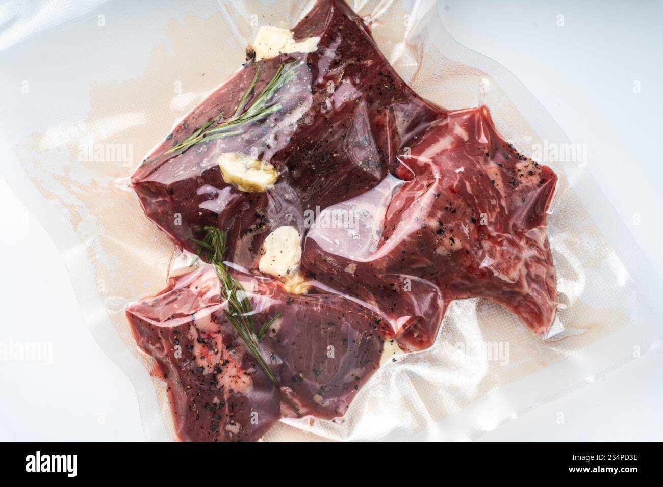 Beef Vacuumed with Rosemary cooked sous vide on a white background ...