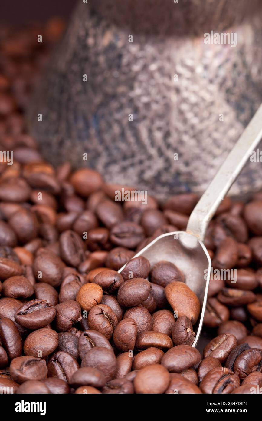 spoon scoops roasted coffee beans and copper coffee pot close up Stock ...