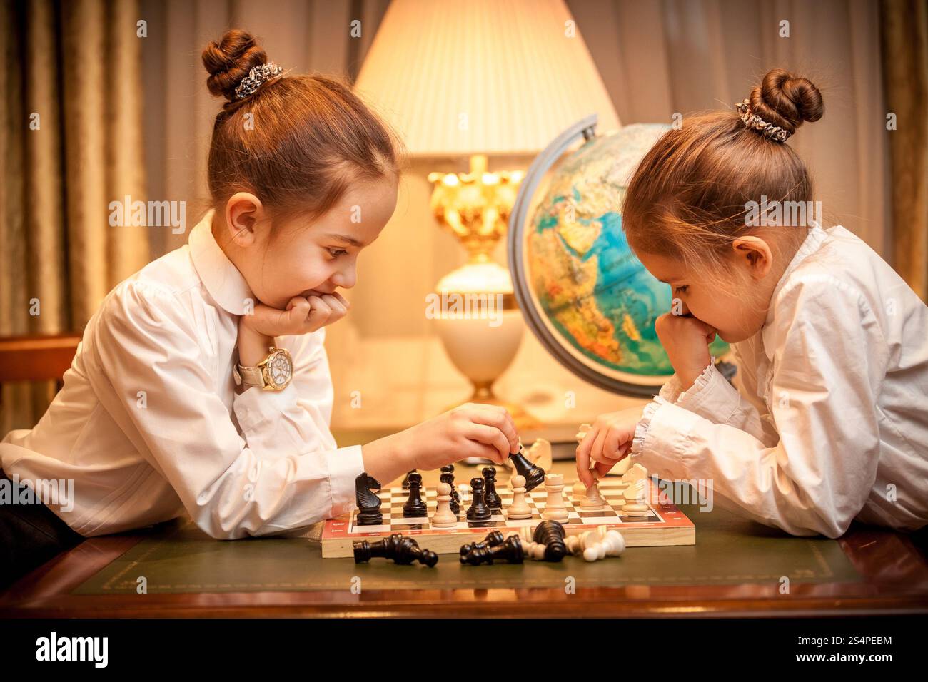Girls in school uniform playing chess at cabinet Stock Photo - Alamy