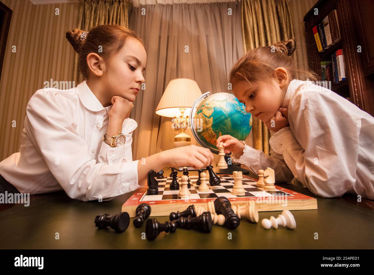 Portrait of two little sisters playing chess Stock Photo - Alamy