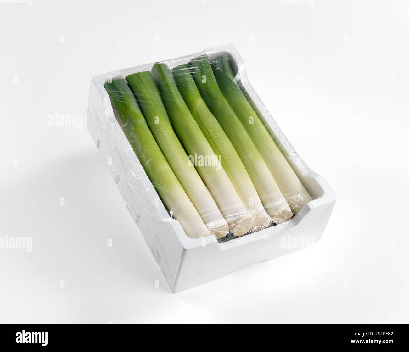 Box of leeks on white background Stock Photo - Alamy