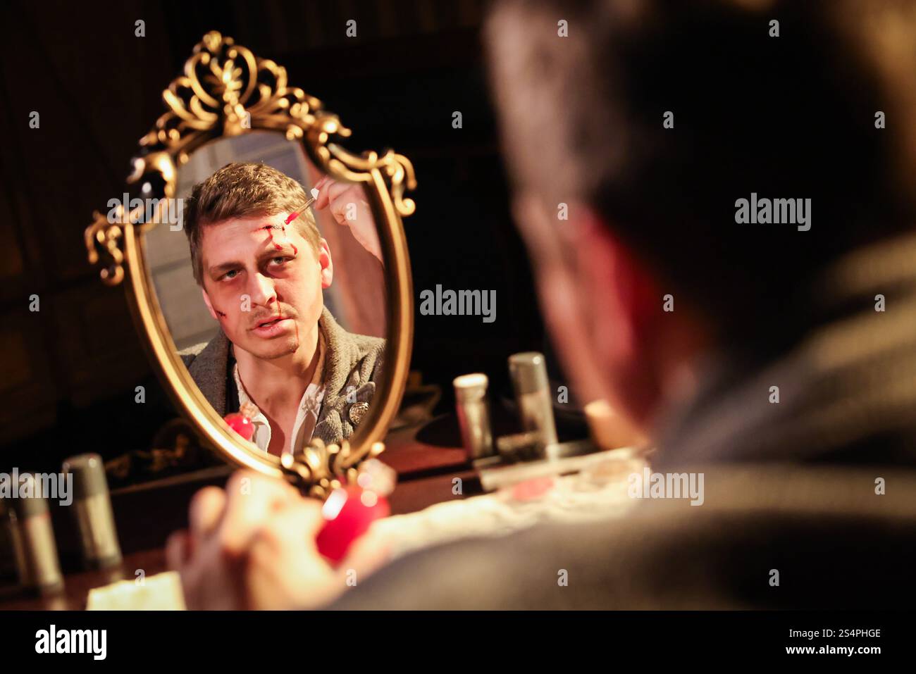 Hamburg, Germany. 13th Jan, 2025. Actor Marcel Casper applies make-up to a wound during a photo ...