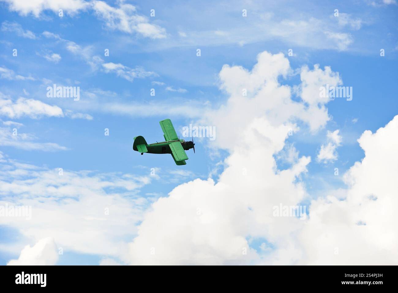 small green plane flying in blue sky in summer day Stock Photo - Alamy