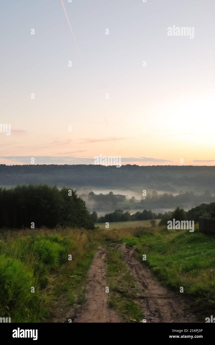 country road and fog over river in summer twilight, Russia Stock Photo ...