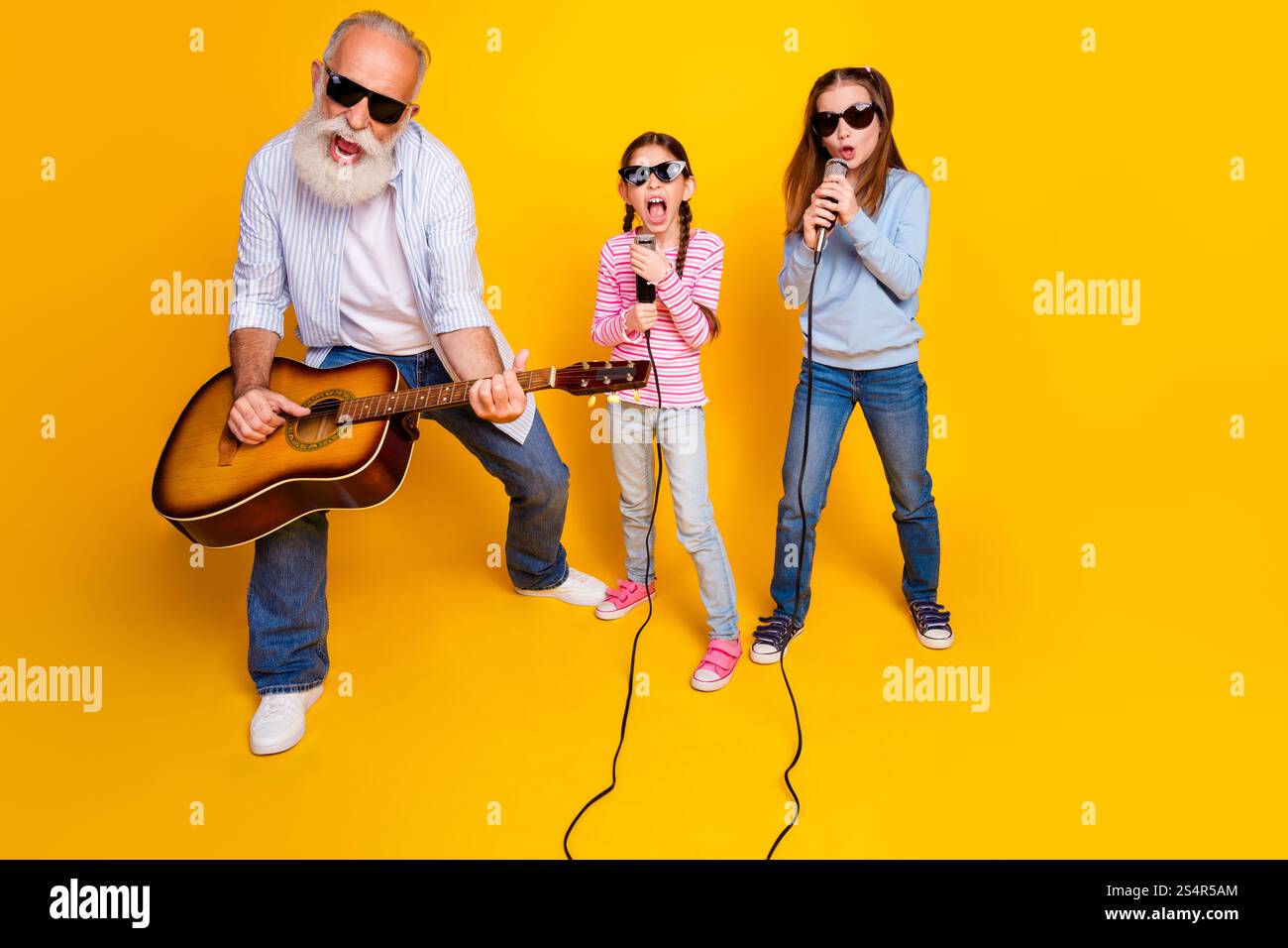 Three generation family band playing music on yellow background showing ...