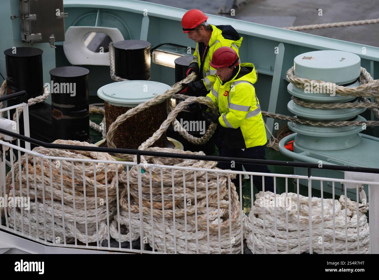 Workers pull ropes on board The Glen Sannox ferry ahead of departing ...