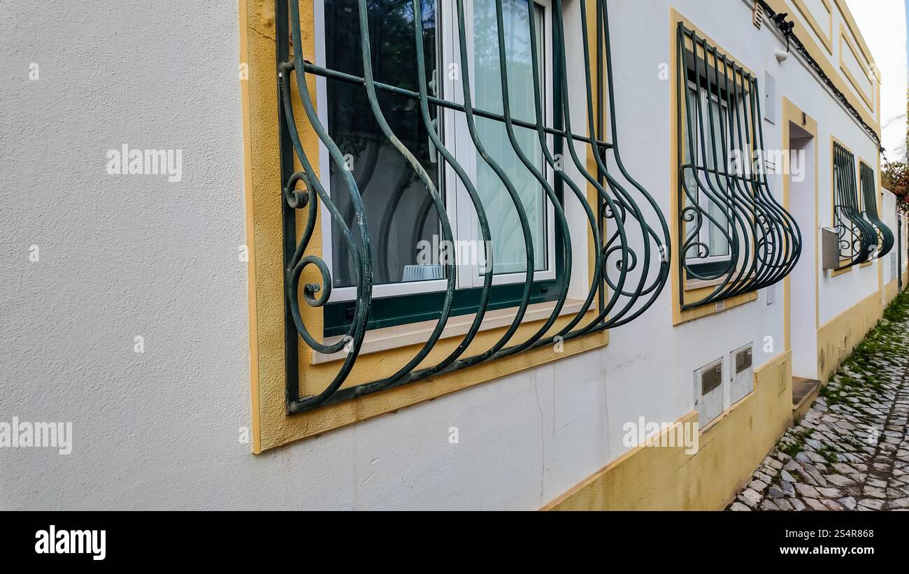 metal fencing on windows in ferragudo Stock Photo - Alamy