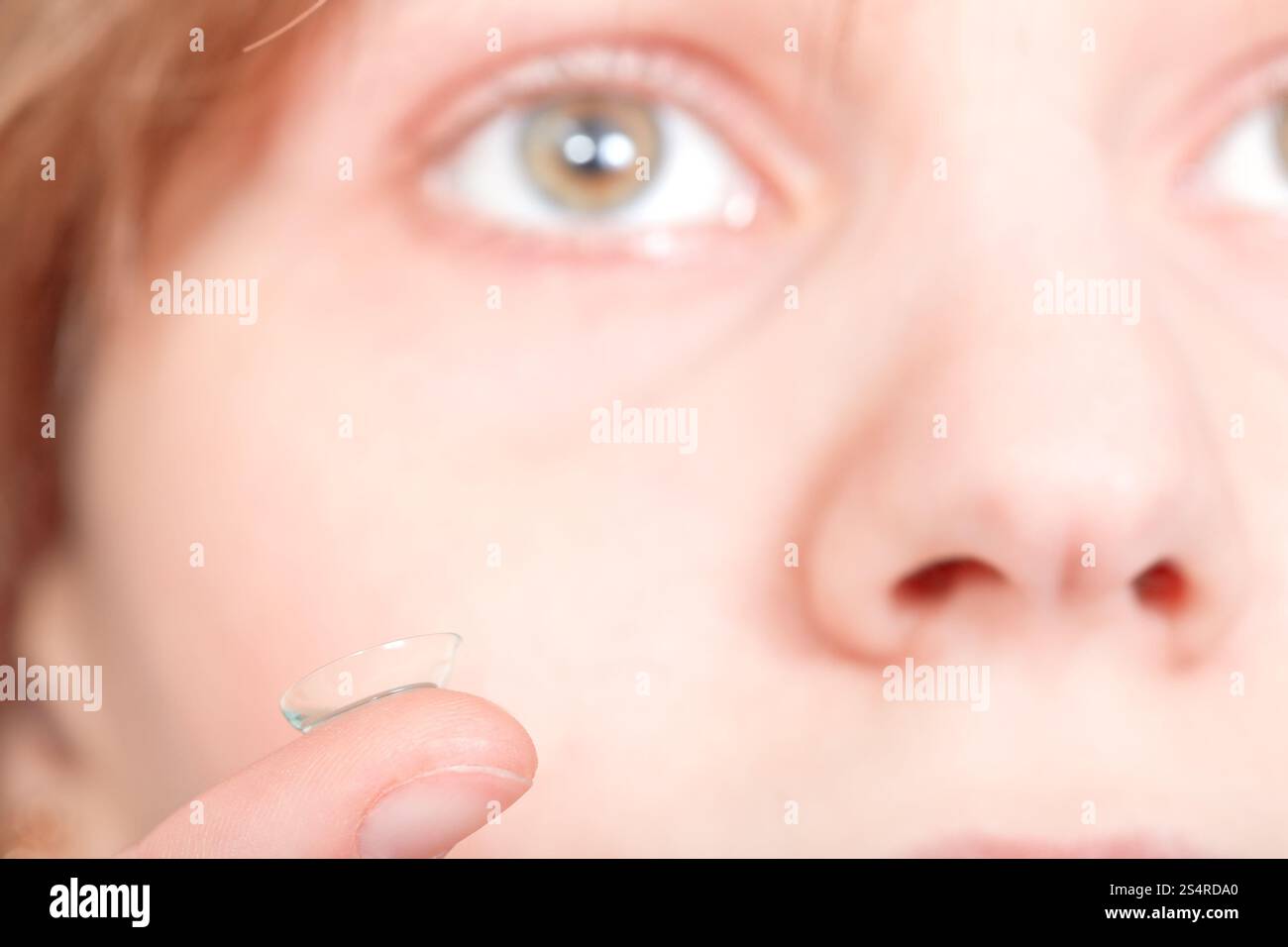 finger with contact lens in front of female face close up Stock Photo ...
