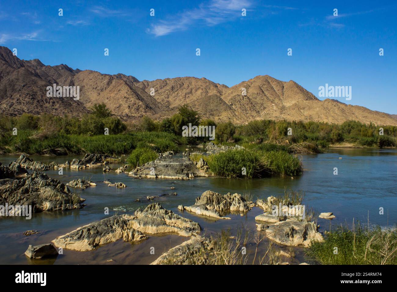 The Orange River, flowing between the barren desert mountains along the border between South ...