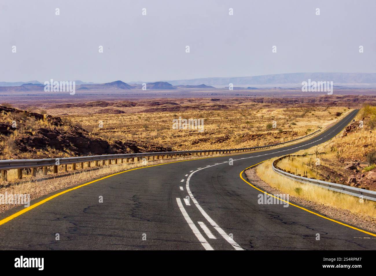 Long empty road descending into the arid plains of the Nama Karoo ...