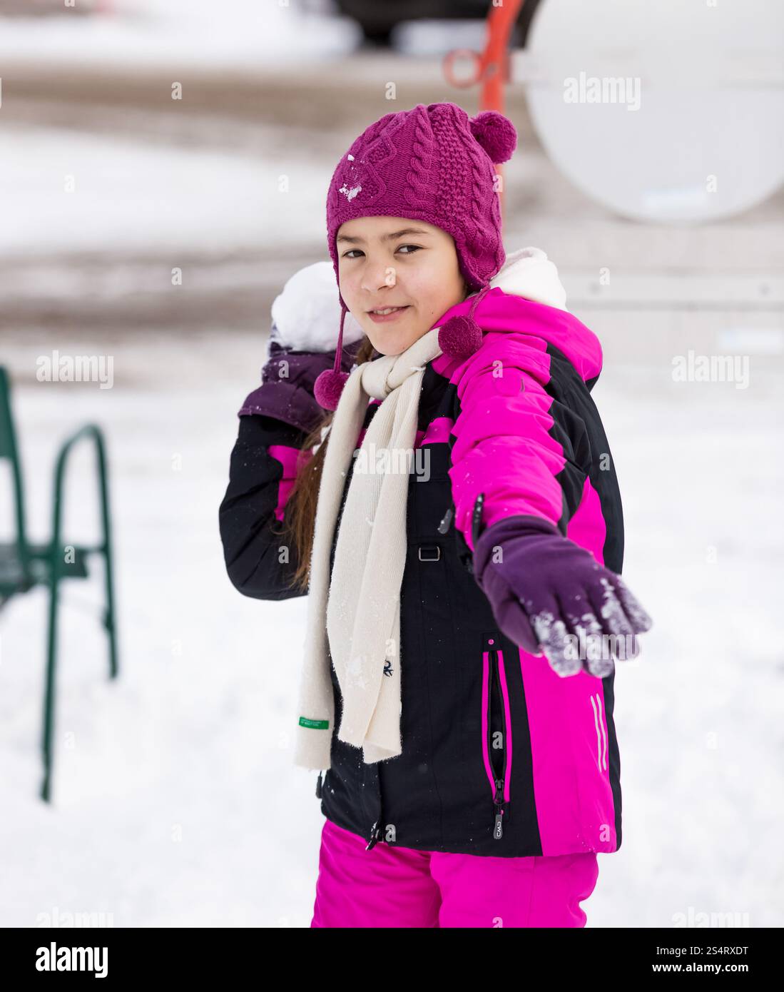 Portrait of cute girl throwing snowball at camera Stock Photo - Alamy