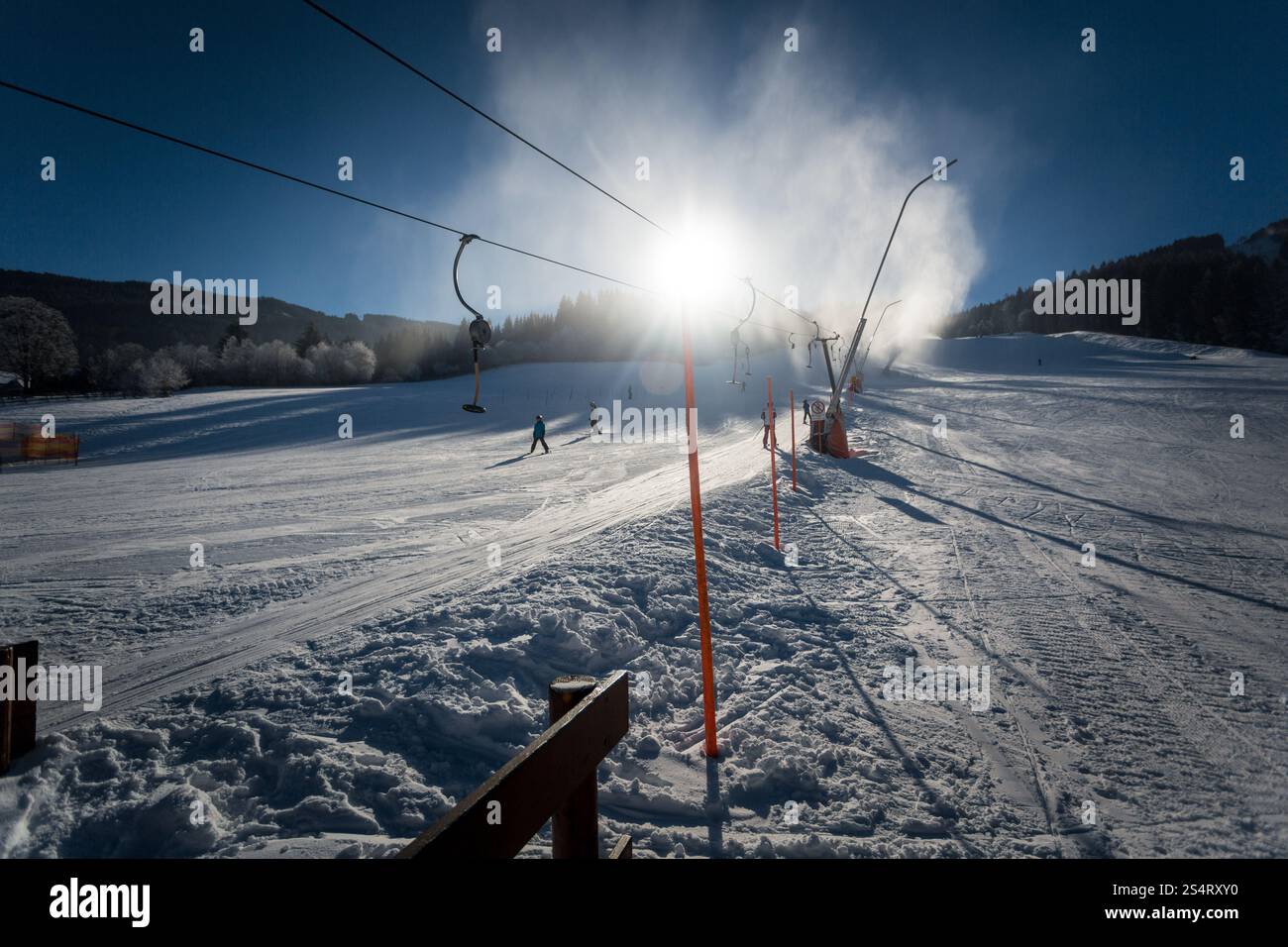 Long fast ski slope with working snow cannons at sunny day Stock Photo ...