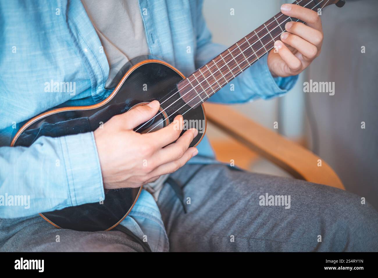 Close-up perspective captures a man's fingers plucking the strings of a ...