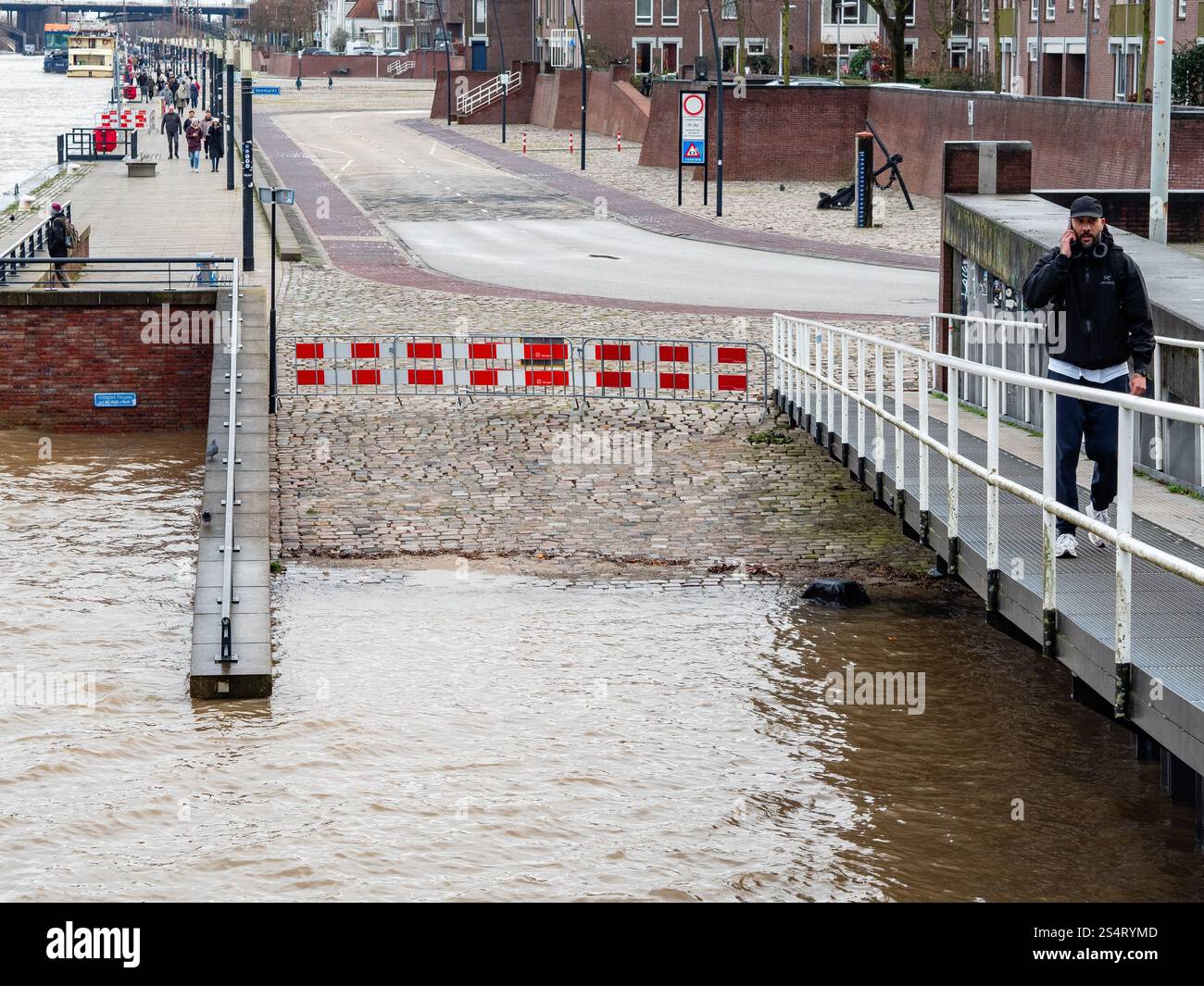A man is seen walking next to a flooded area in the harbor. The short ...