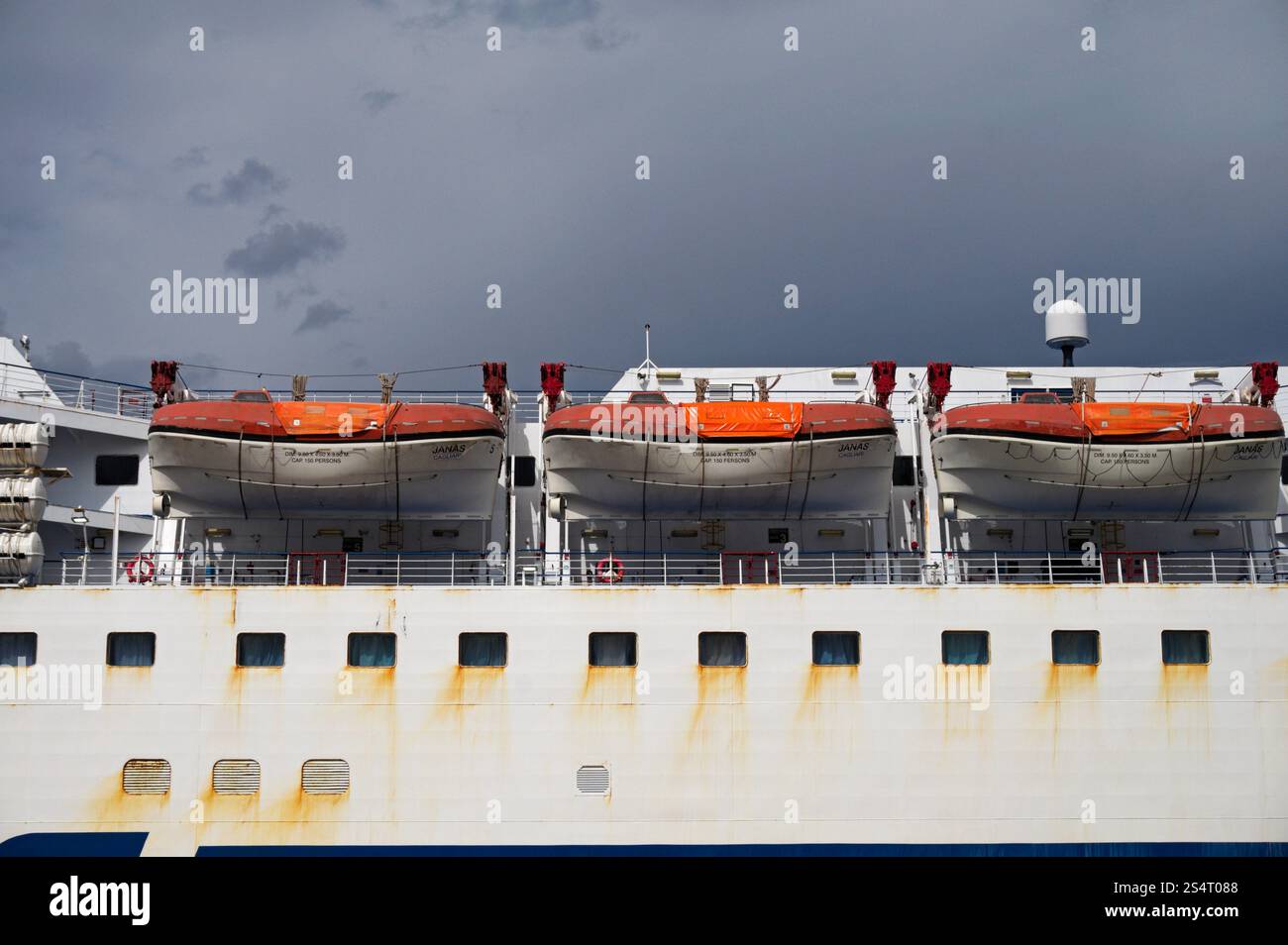 lifeboats hanging on the side of a cruise ferry ship with rust stains ...