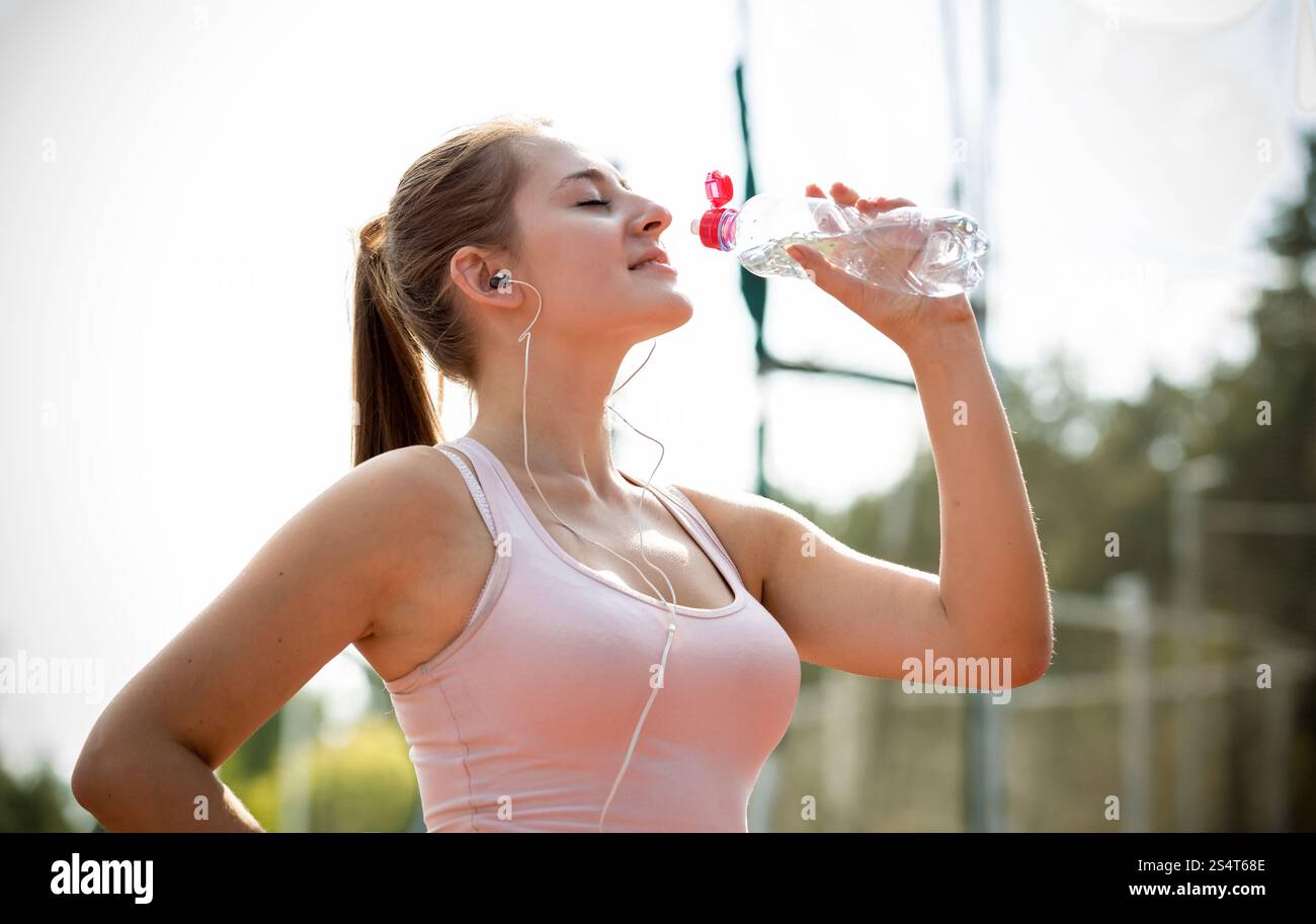 Closeup portrait of young slim woman having break at running and ...