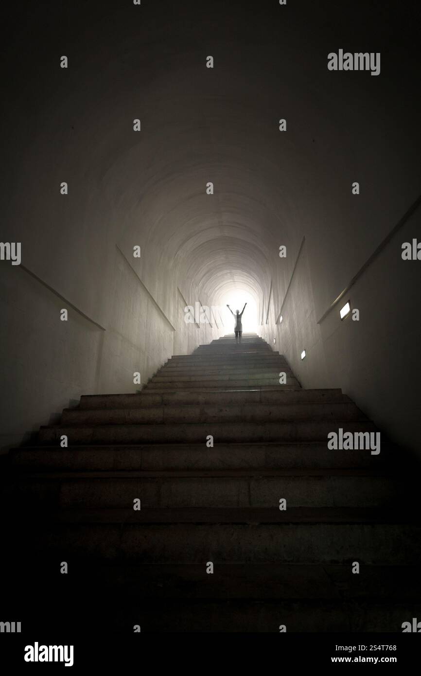 Conceptual photo of person standing in the end of tunnel at light beam ...