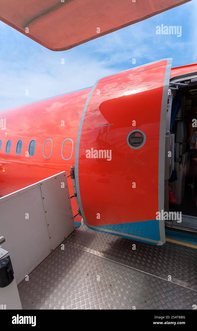 Photo of open door of big civil airplane painted in red Stock Photo - Alamy
