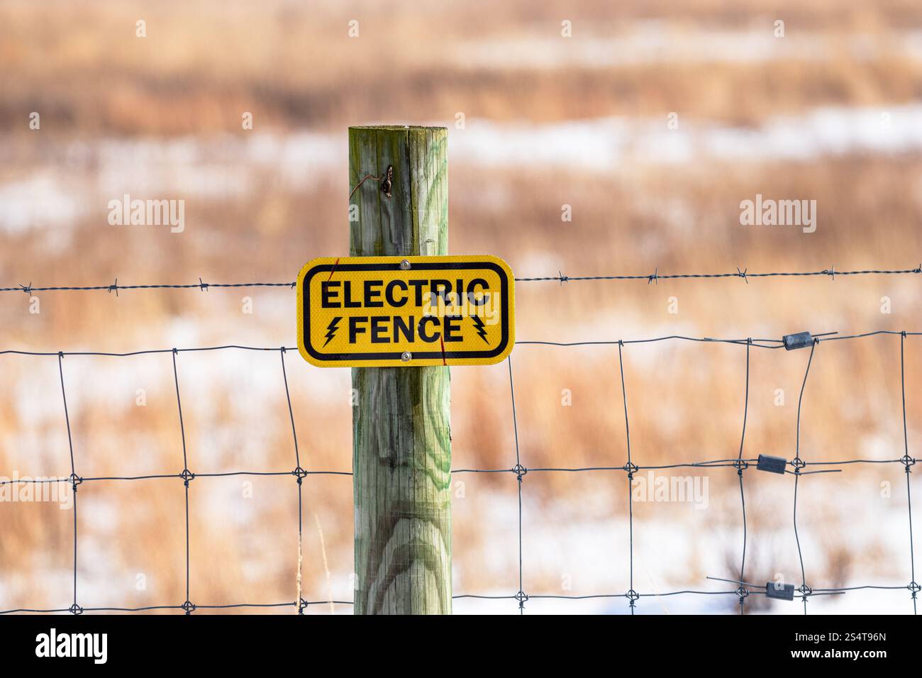 Electrical Fence sign on a fence post in winter Stock Photo - Alamy