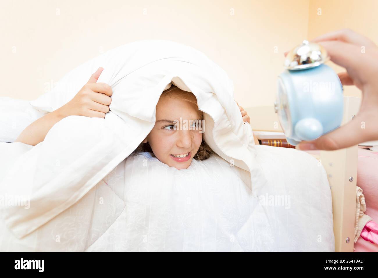 Portrait of little girl being was awakened by alarm clock Stock Photo ...
