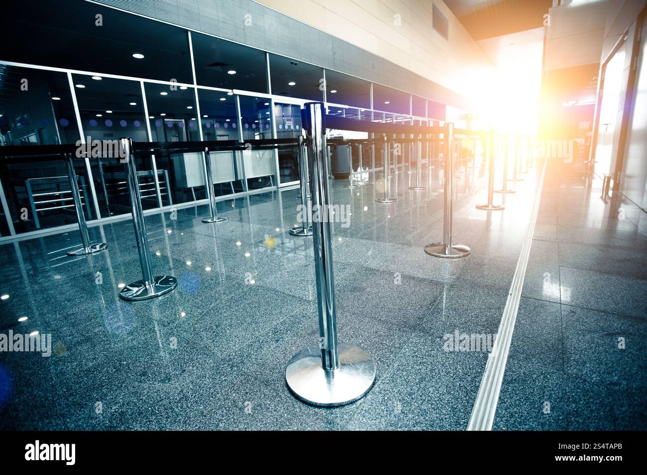 Photo of empty airport check-in line lit by sun beam Stock Photo - Alamy