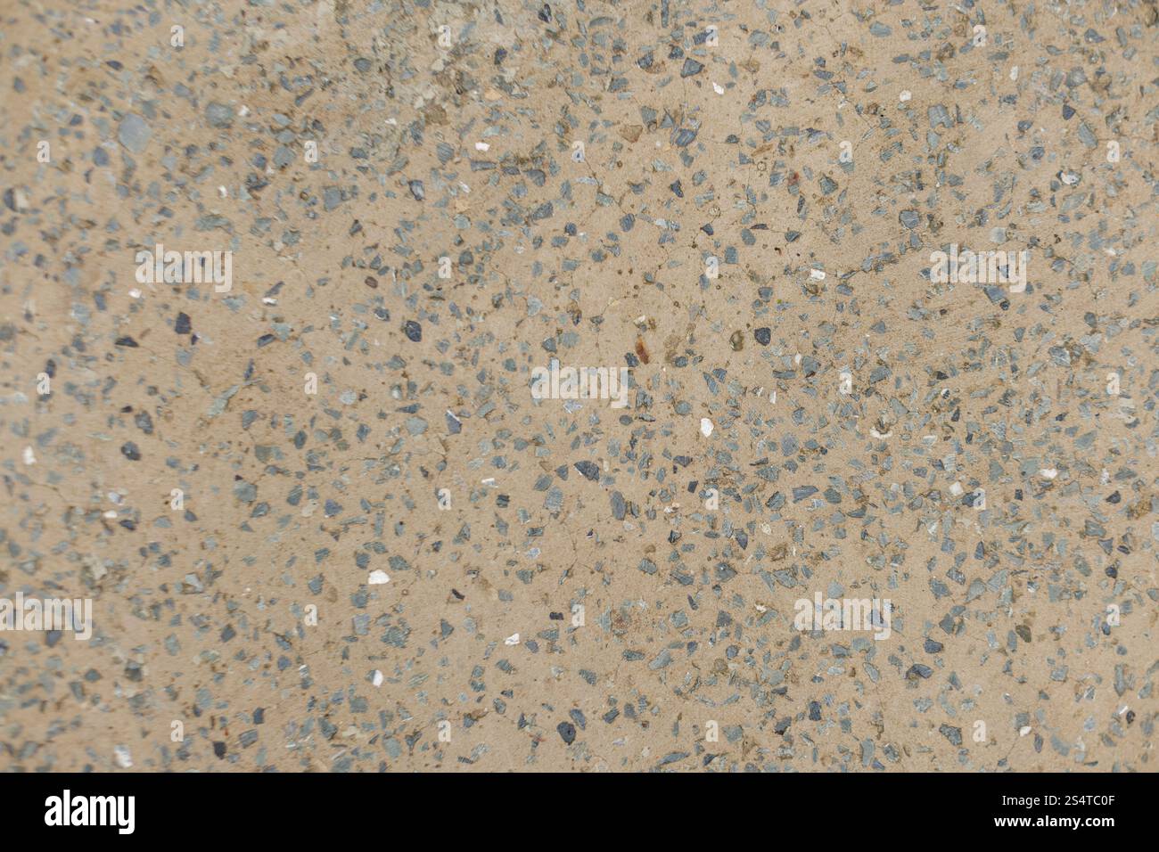 Top down view of a concrete sidewalk showing small stones embedded in ...